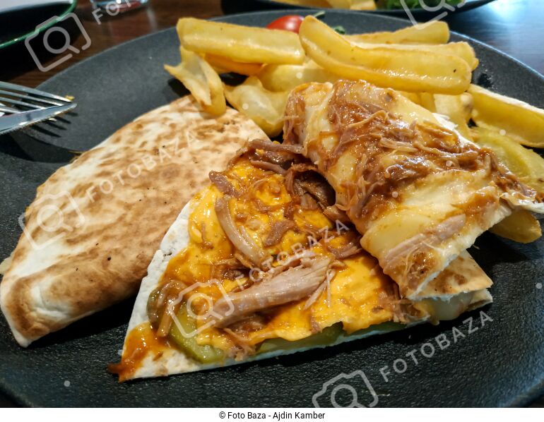 Tortilja sa mesom servirana na stolu u restoranu. - preuzmite ...